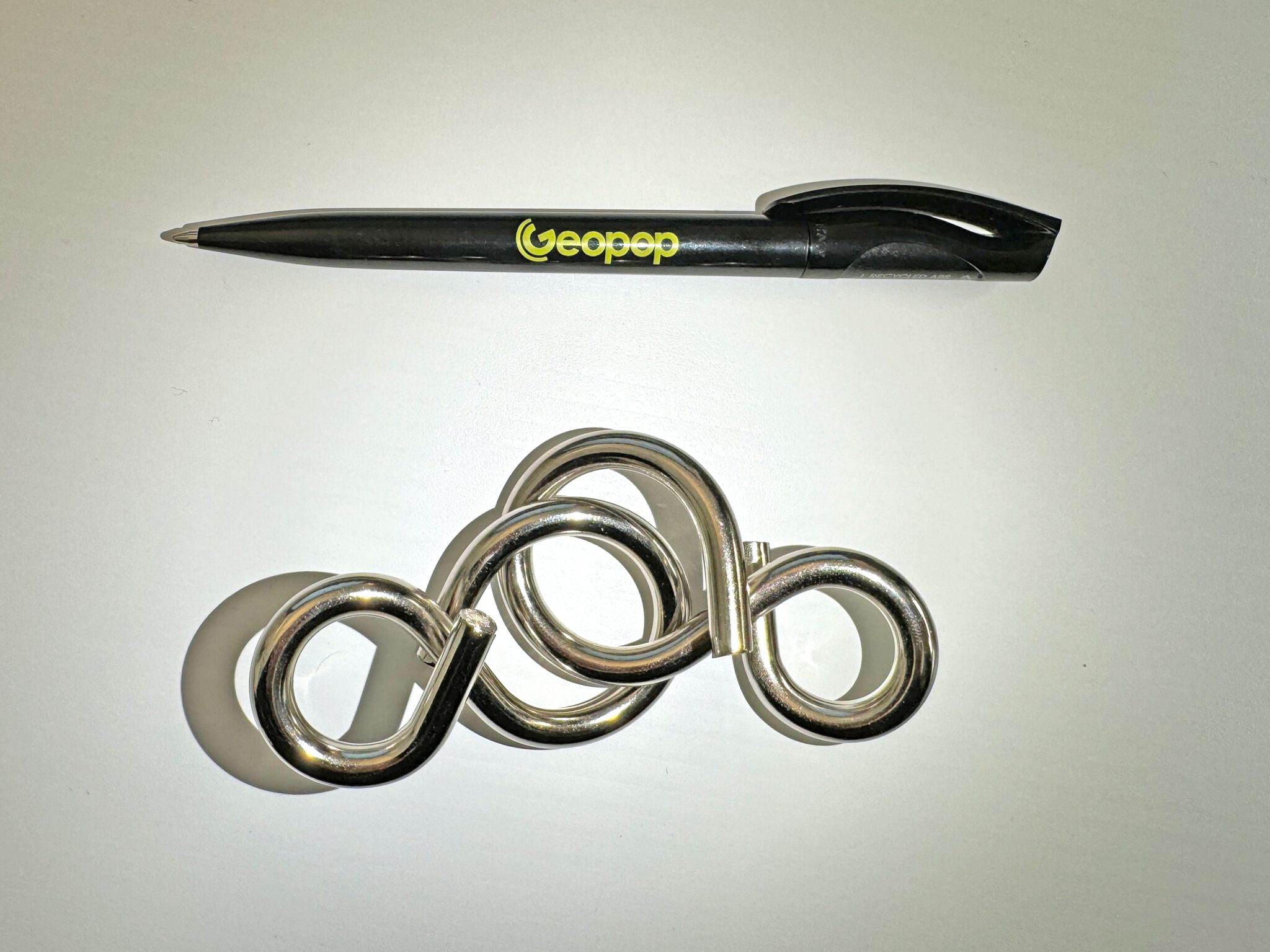 Metal puzzle, how to remove one ring from another: the solution